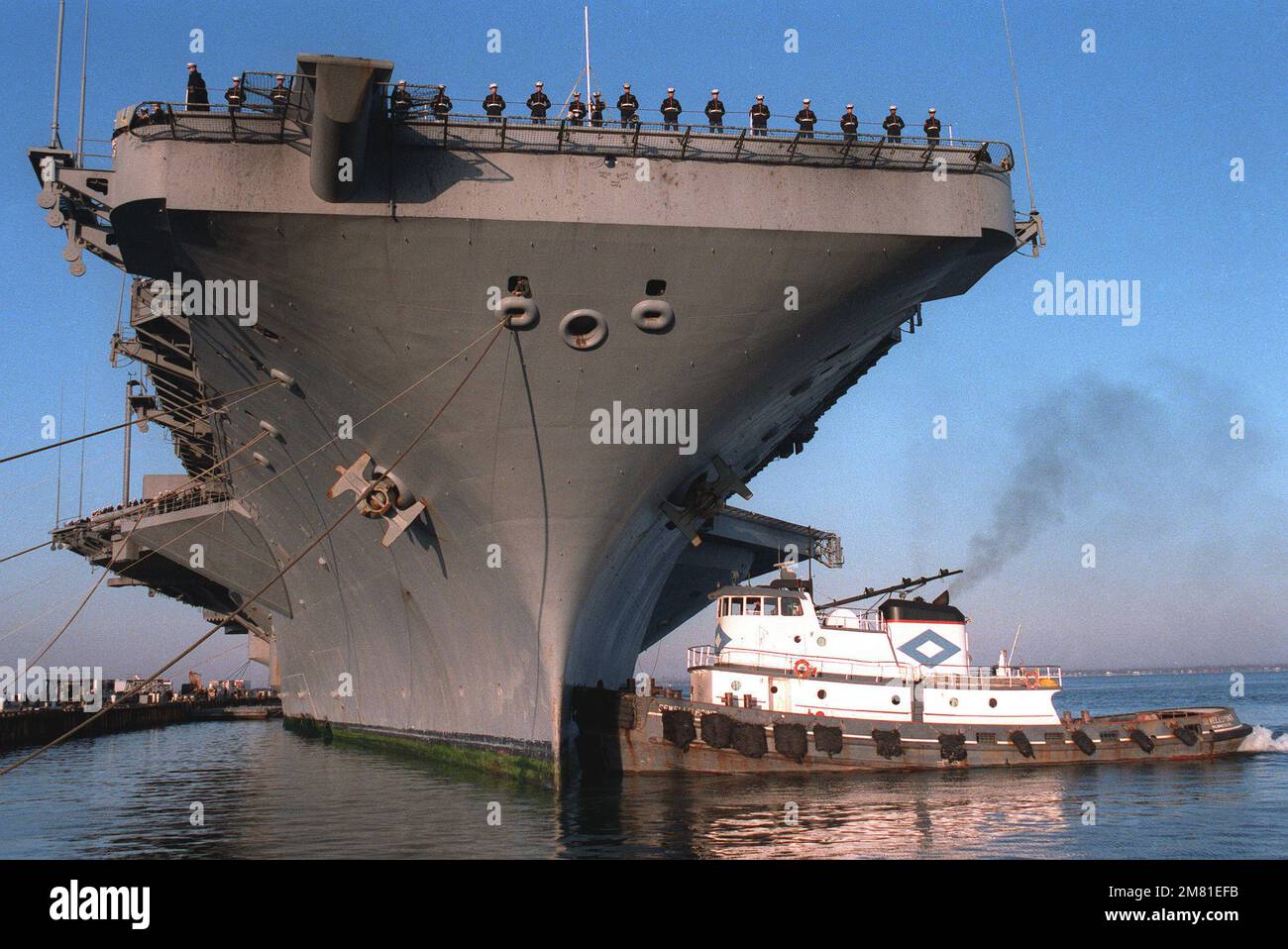 A tug maneuvers the nuclear-powered aircraft carrier USS DWIGHT D ...