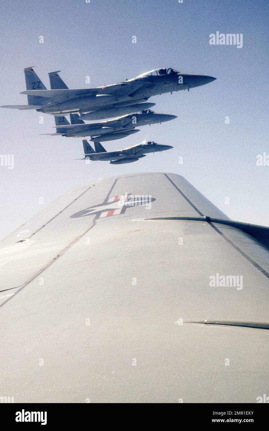 An air-to-air right side view of three F-15 Eagle aircraft in use ...