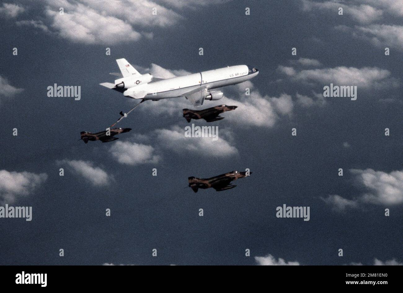 An air-to-air side view of a KC-10 Extender aircraft refueling an F-4 ...