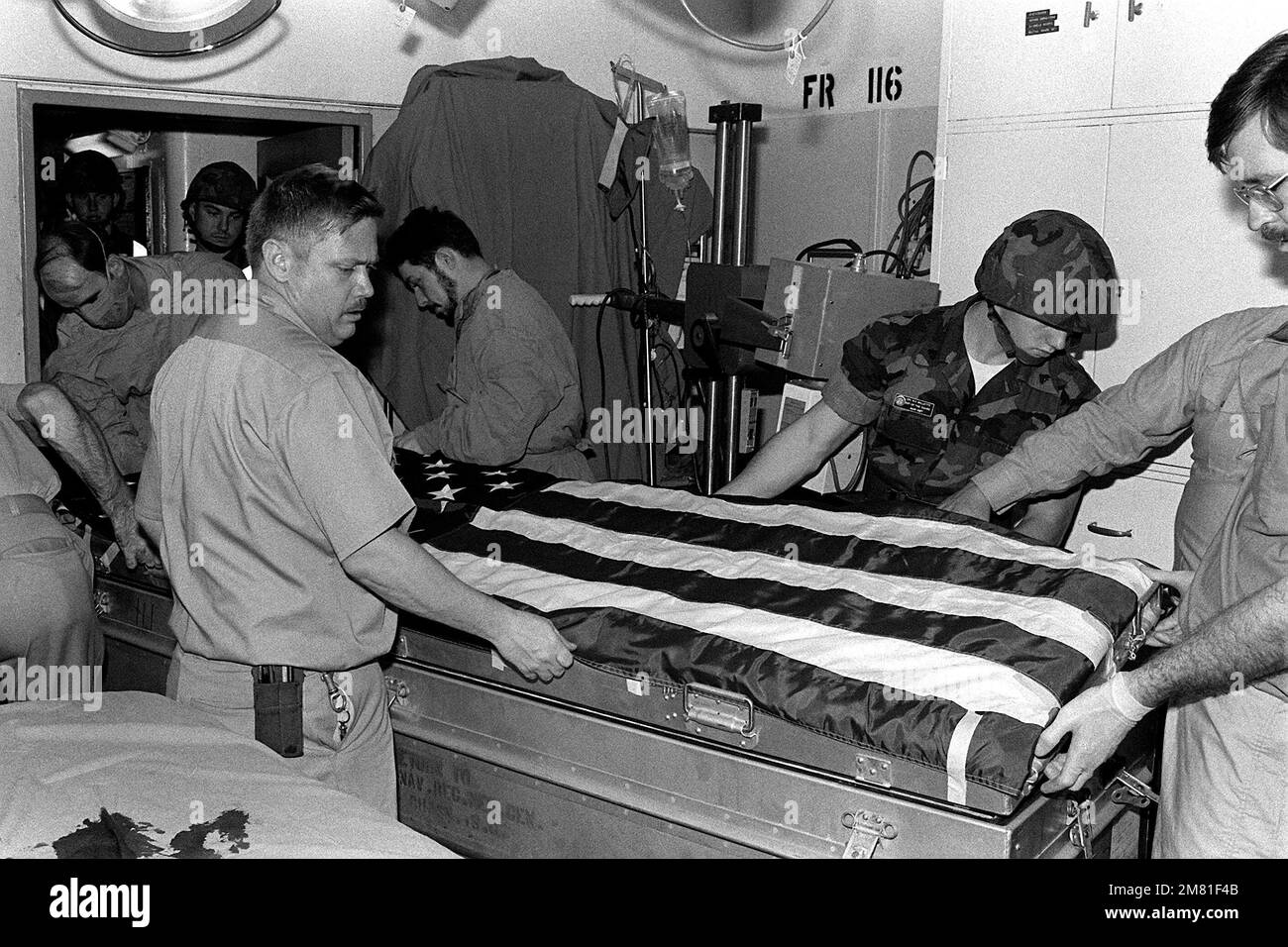 The flag-draped casket of LT. Mark Adam Lange is prepared for transport ...