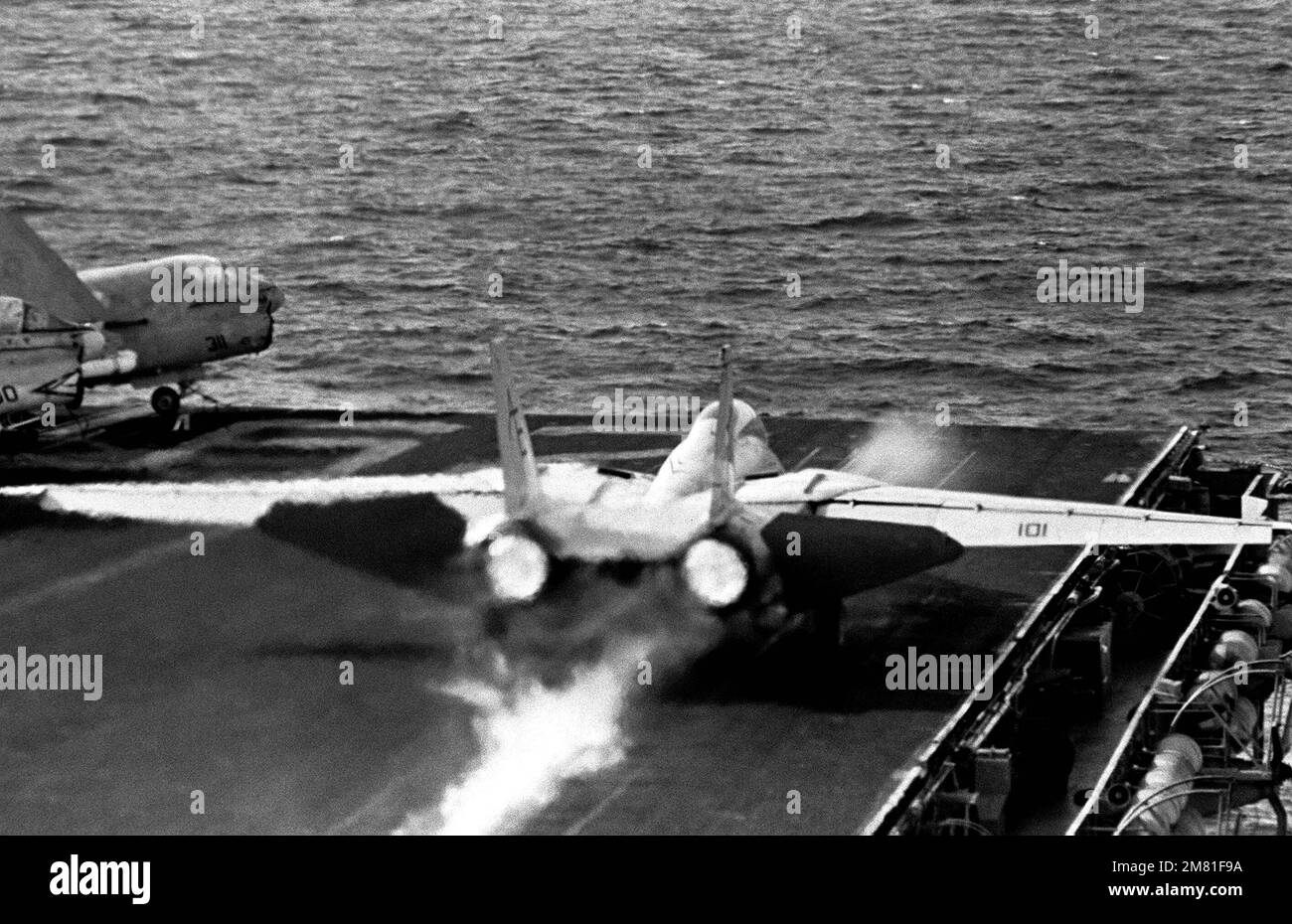An F-14 Tomcat aircraft takes off from the flight deck of the aircraft ...