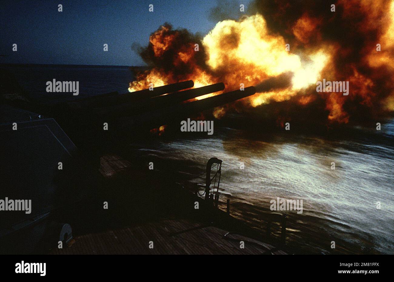 Smoke and flames shoot out from 16-inch guns of the battleship USS NEW ...