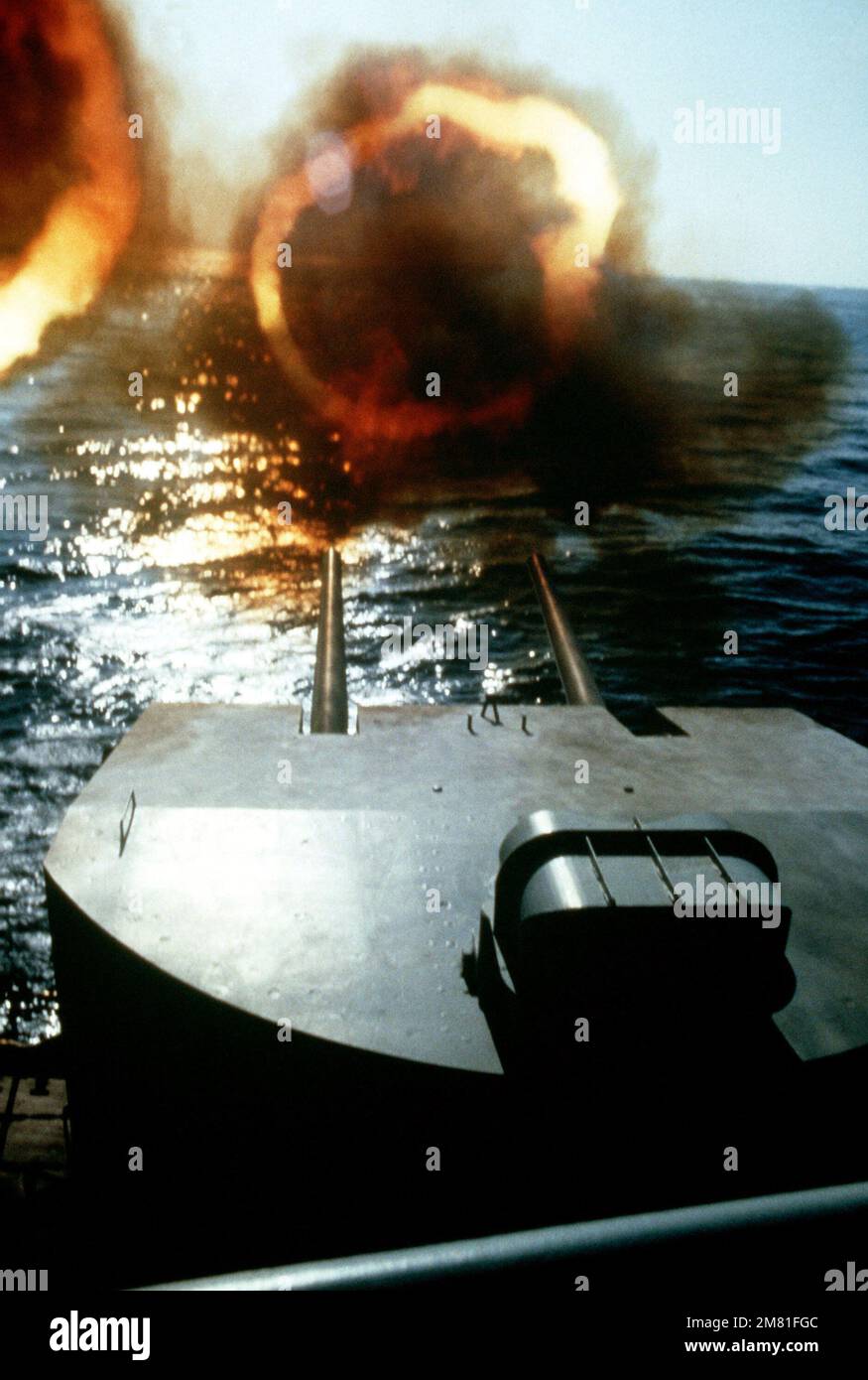 Rings of fire erupt from one of the 5-inch/38-caliber twin gun mounts ...