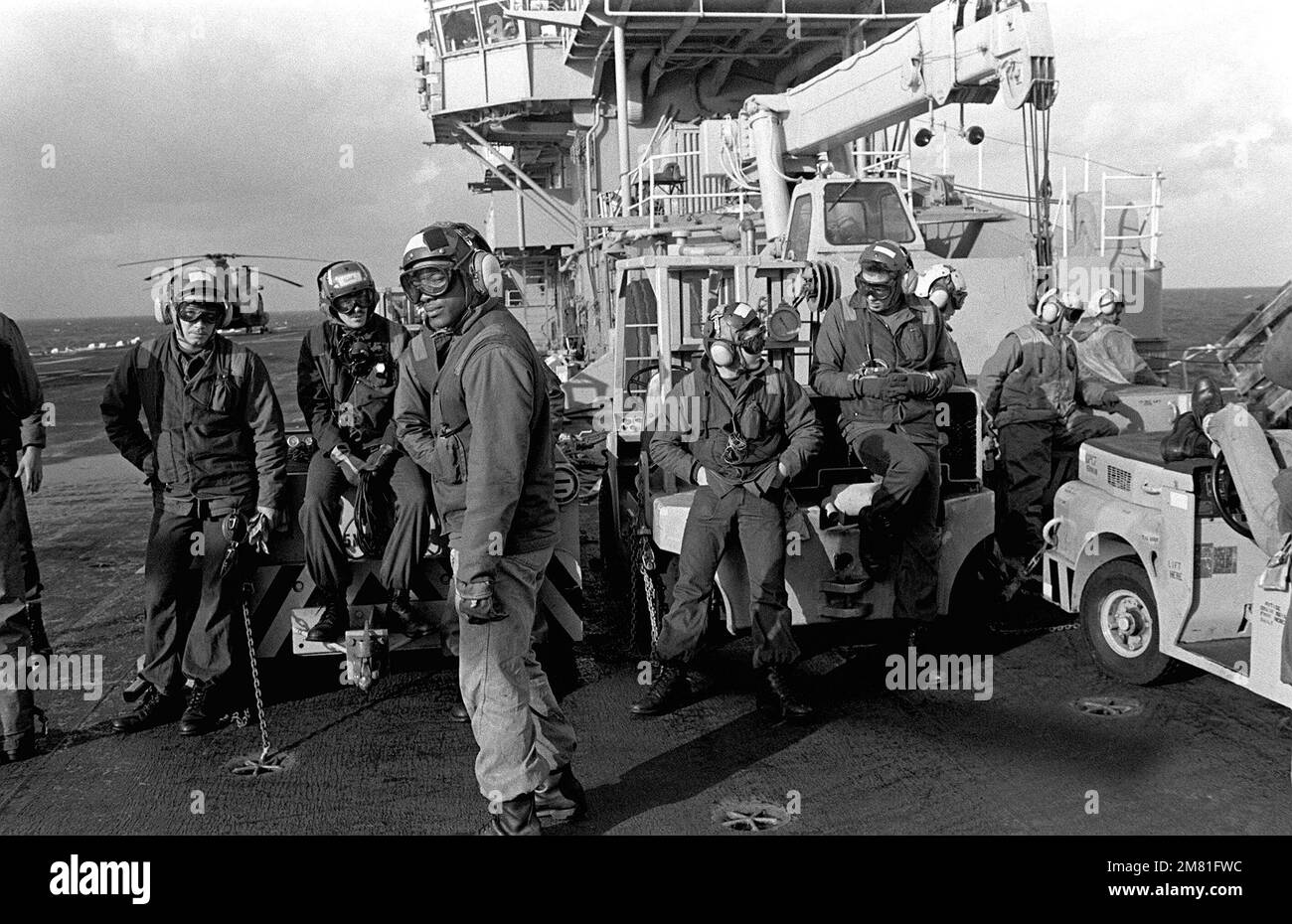 A view of several crewmen on the flight deck of the amphibious assault ...