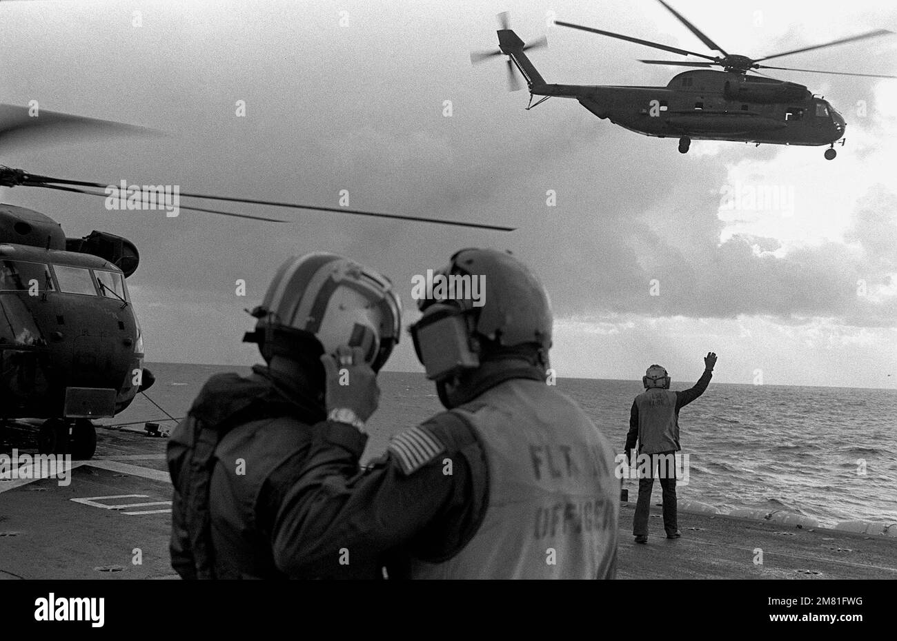 Two crewmen discuss their duties on the flight deck of the amphibious ...