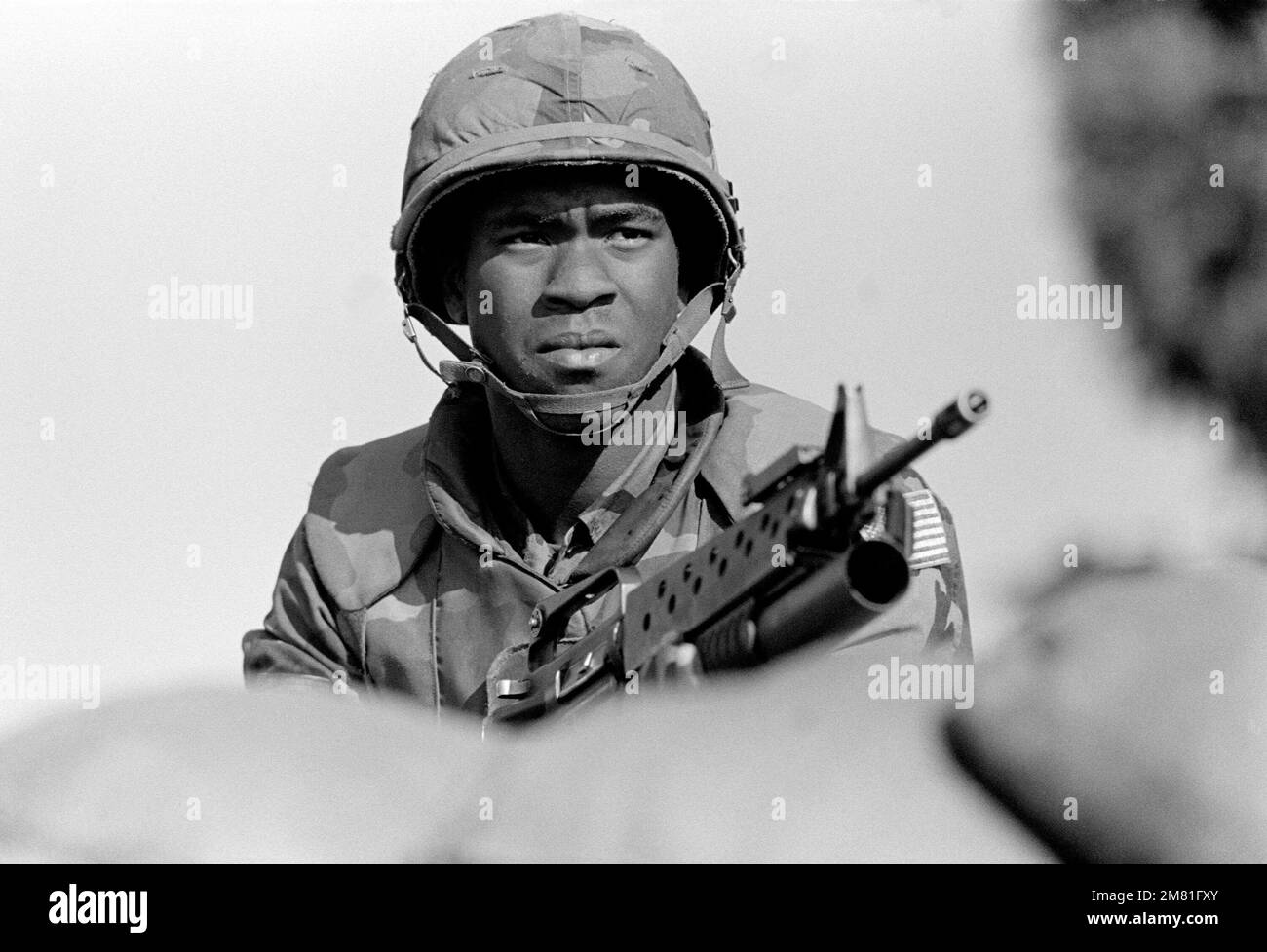 A Marine armed with an M-203 grenade launcher stands guard in a bunker ...