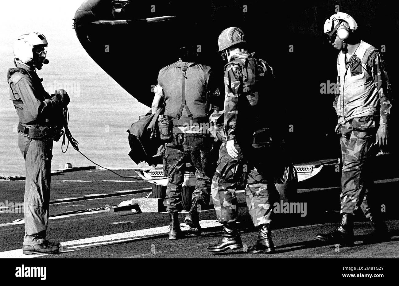 Marines prepare to board a helicopter for transfer from the amphibious ...