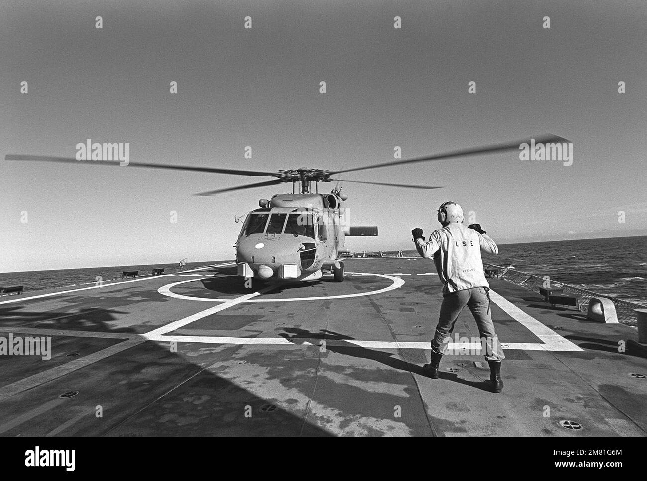 A plane director signals instructions to the pilot of the Navy's first ...