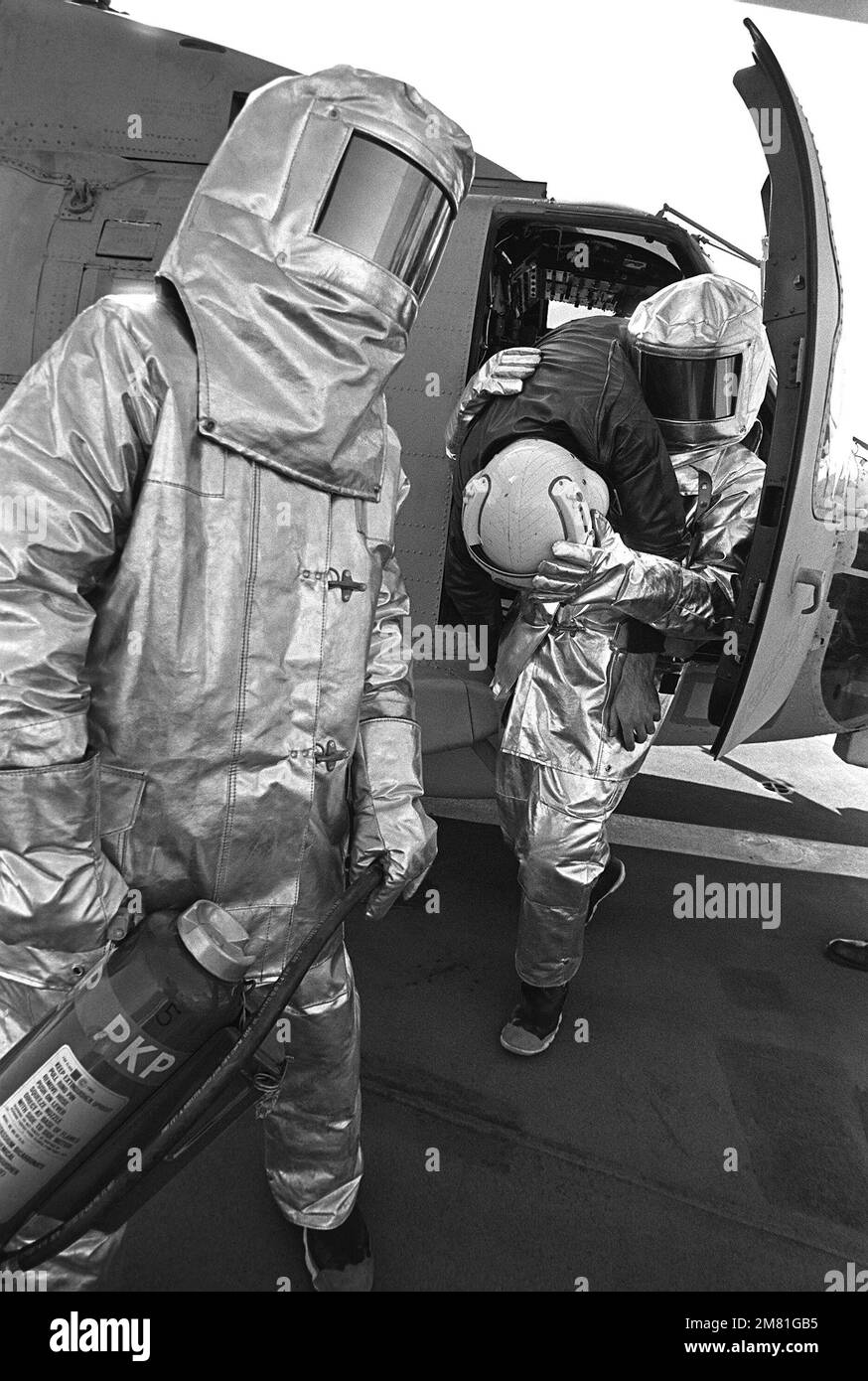 Firemen carry a crew member from the cockpit of the Navy's first ...
