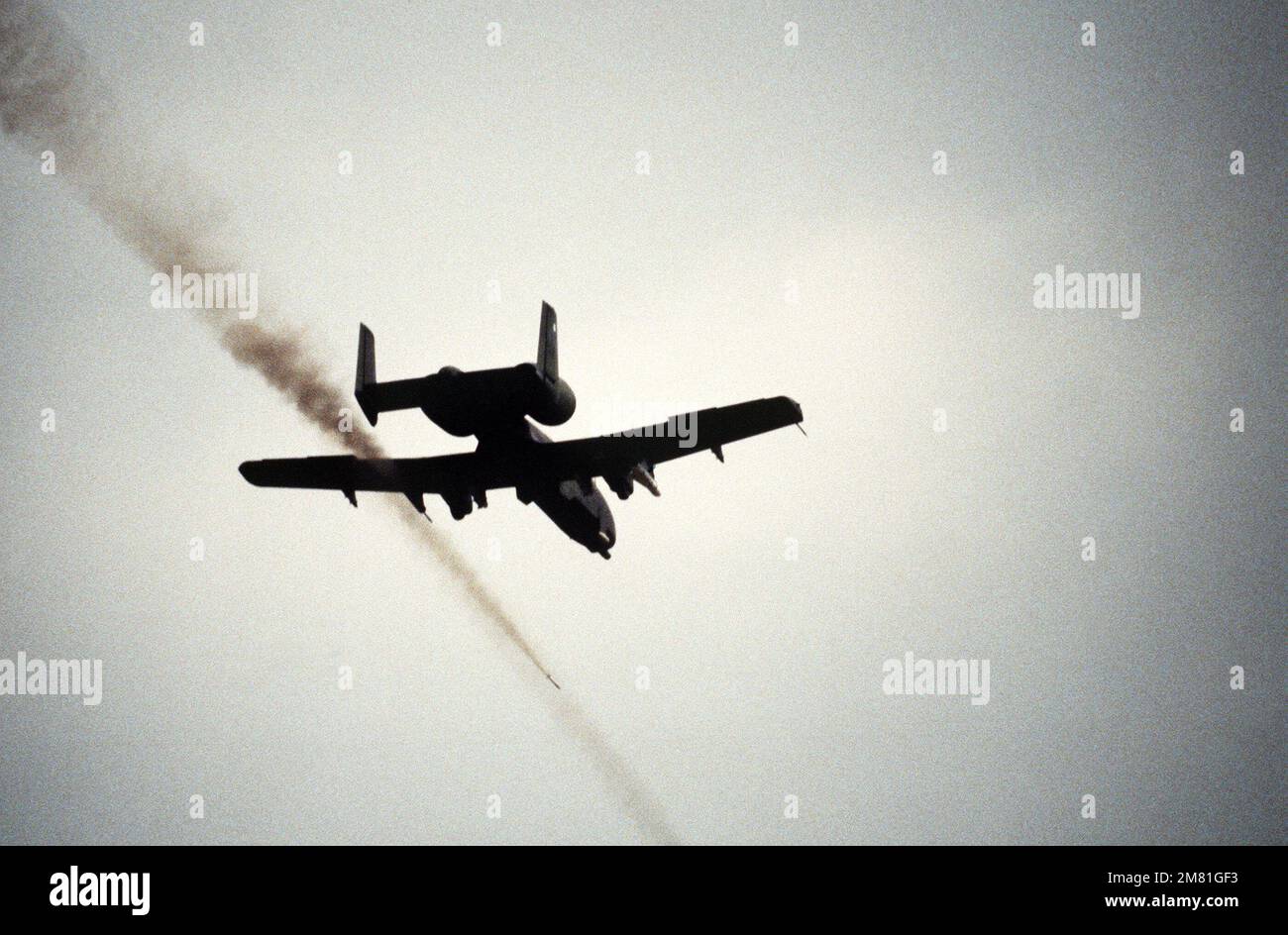 Underside view of an A-10 Thunderbolt II aircraft firing a missile over ...