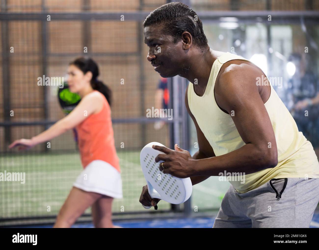 Sporty african american playing padel on indoor court Stock Photo - Alamy