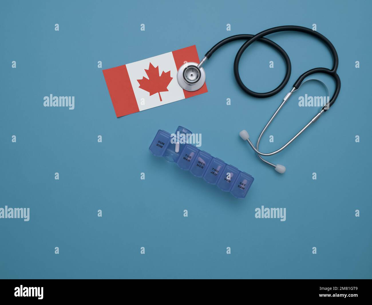 Overhead flat lay of a doctor's stethoscope with a purple weekly pill ...