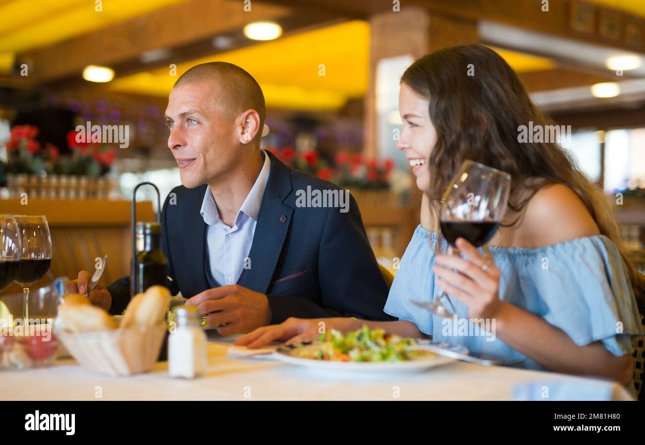 Company of smiling friends having dinner in restaurant Stock Photo - Alamy
