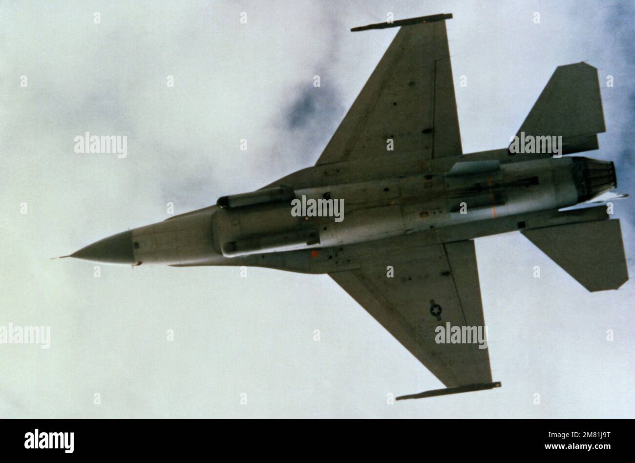 An underside view of an F-16A Fighting Falcon aircraft carrying Low ...
