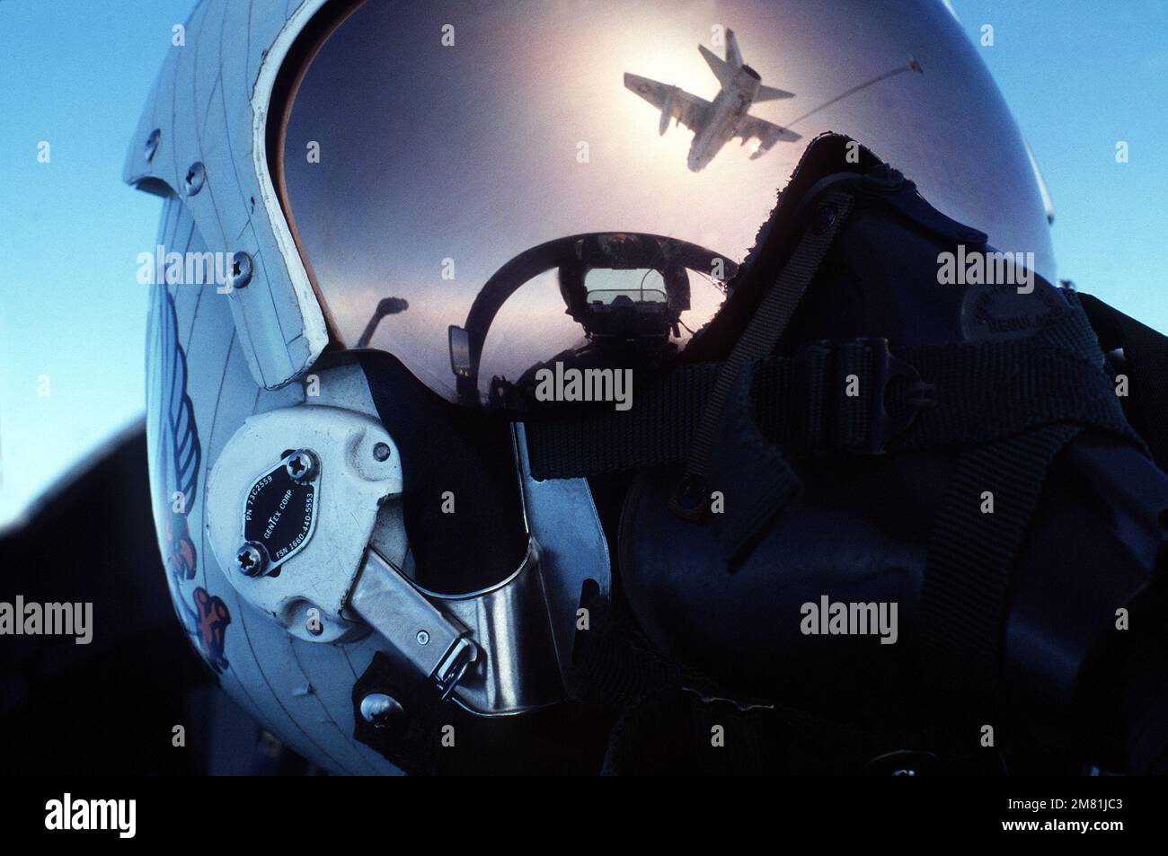 The reflection of an aircraft is visible in the helmet of a pilot from ...