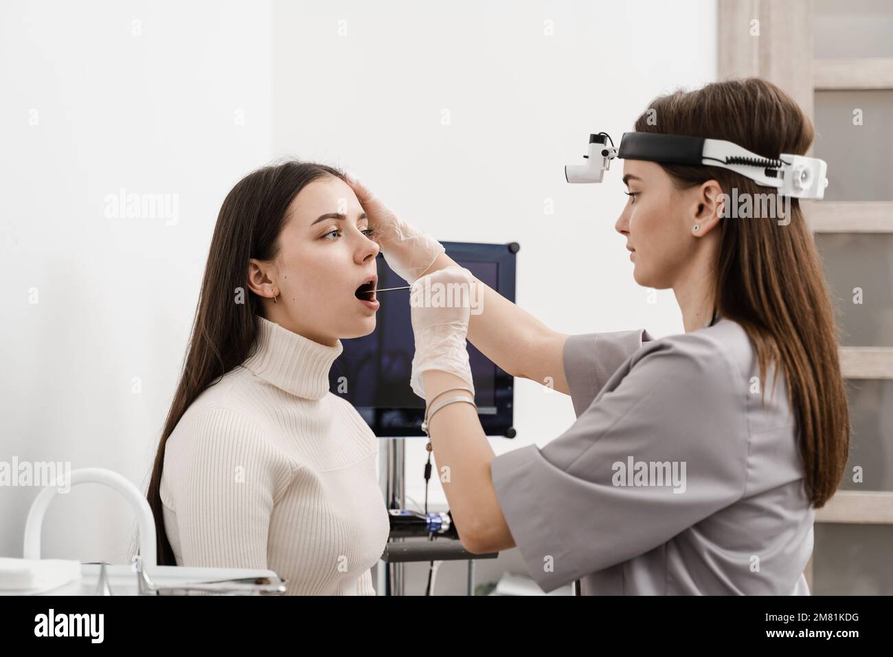 Consultation with laryngologist. ENT doctor doing oropharyngoscopy ...