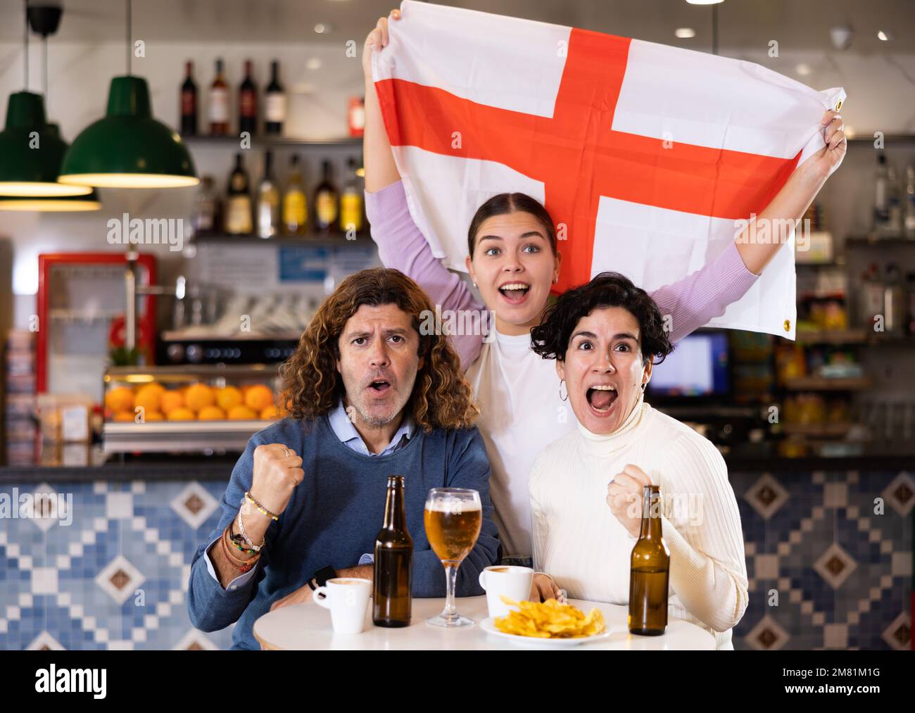 Company of young adult emotional fans supporting English team with ...