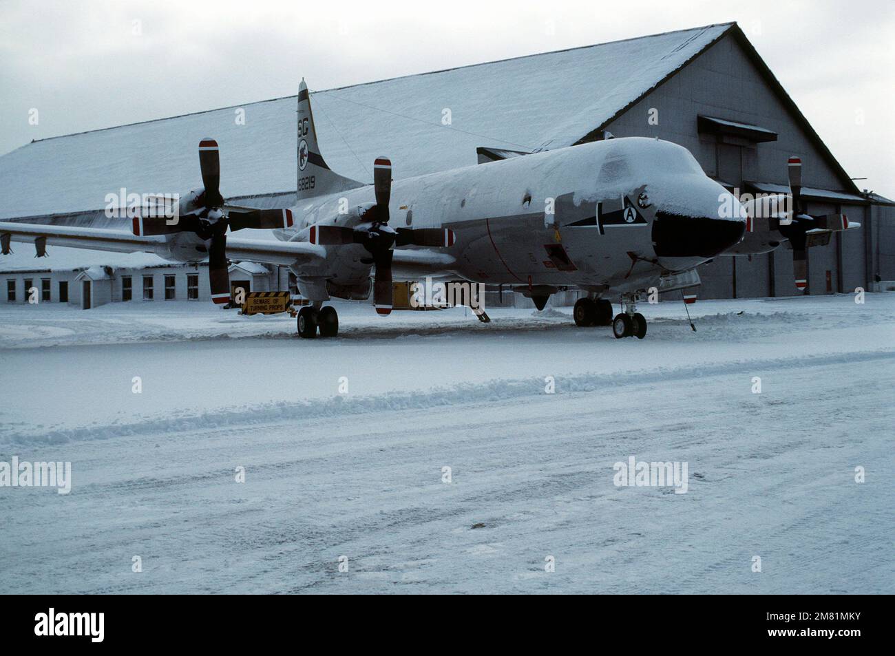 A right front view of a parked P-3C Orion aircraft covered with snow ...