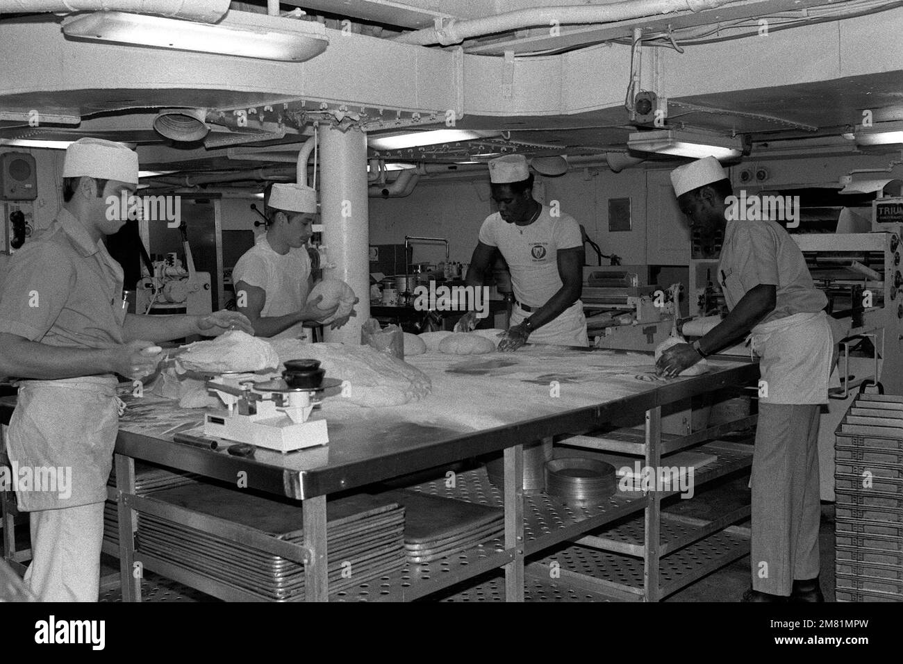 Mess Management Specialists form loaves of bread aboard the aircraft ...