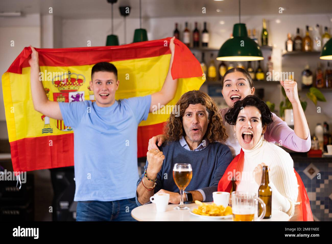 Joyful fans of the Spain team celebrating the victory in night bar ...