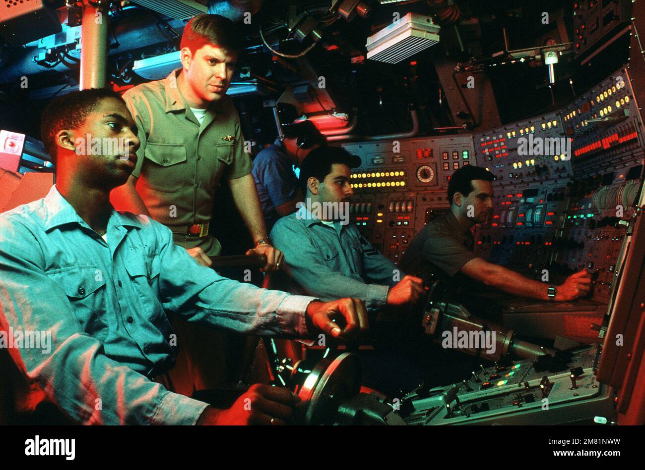 Crewmen monitor consoles at their dive stations in the control room of ...