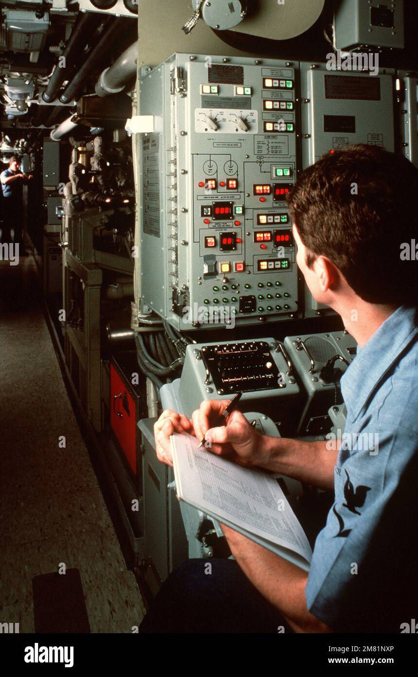 A crewman checks the internal systems of missiles in the missile ...