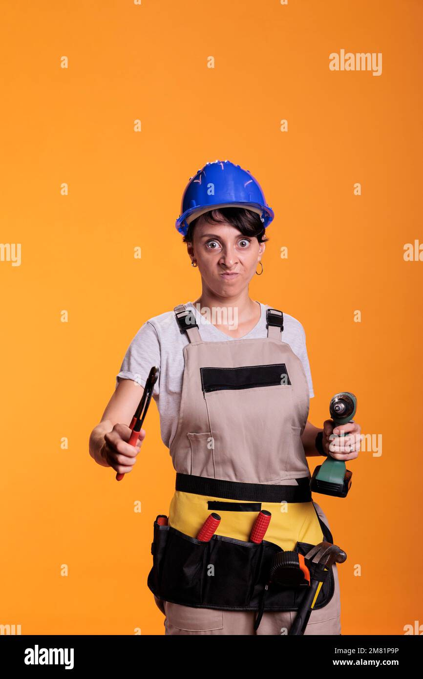 Mad crazy woman contractor posing with renovating tools, holding pair ...