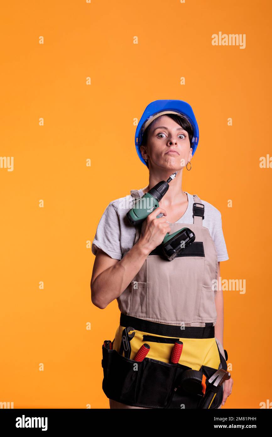 Female repair contractor holding power drill in front of camera, using ...
