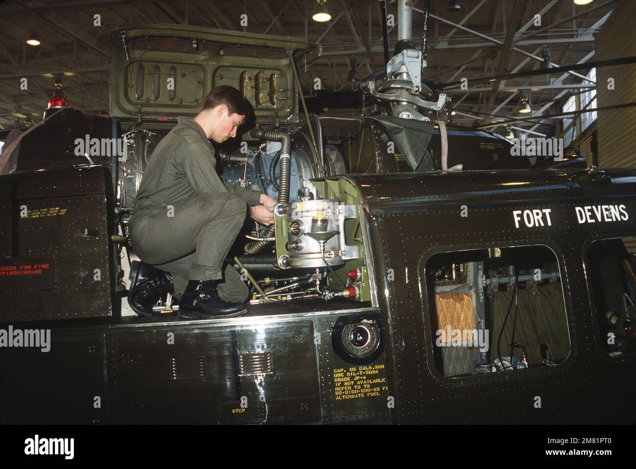 Sergeant Todd L. Glidewell inspects the fitting on the oil tank of a UH ...