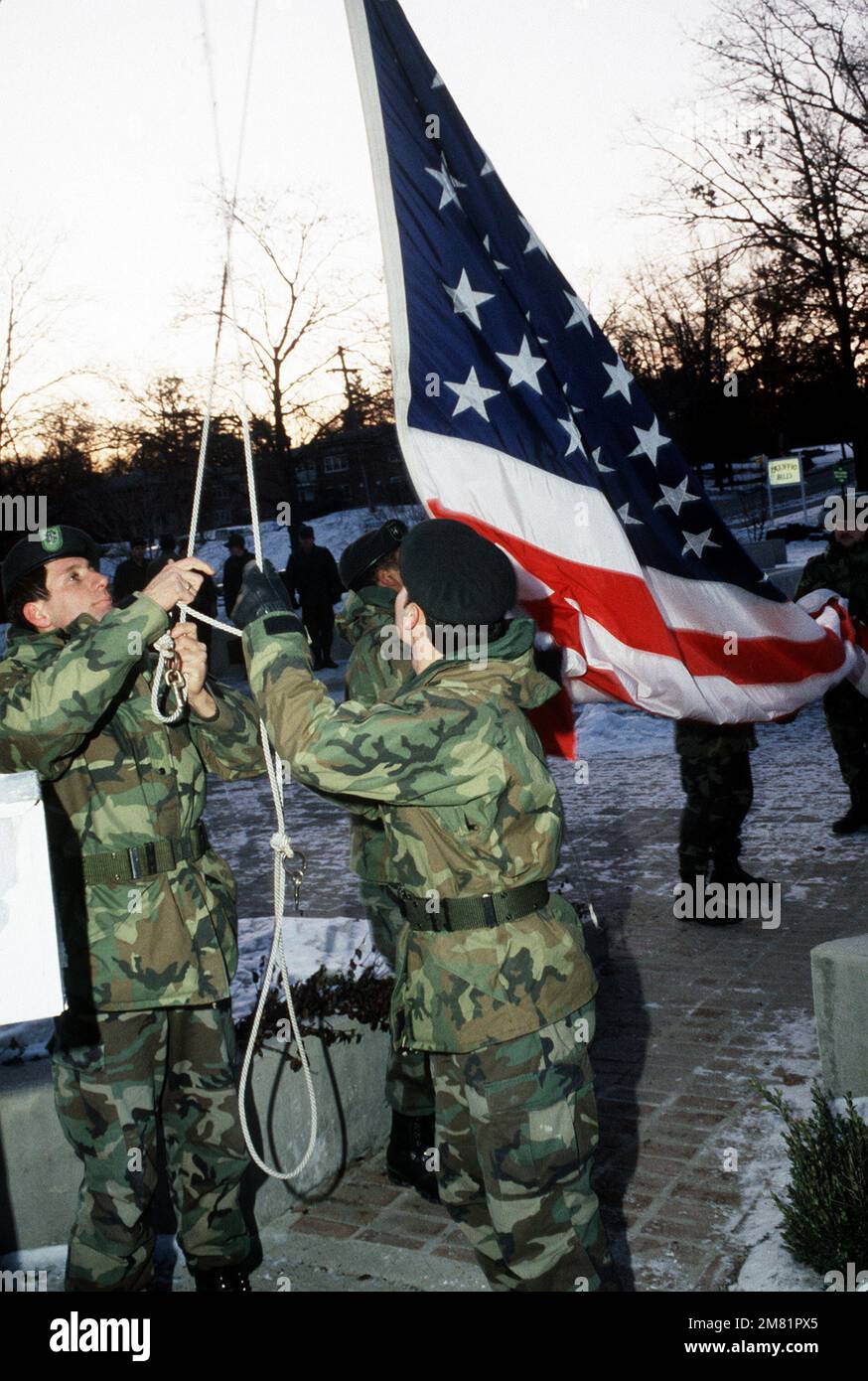 Soldiers of the 10th Special Forces Group (Airborne) lower the flag during the retreat ceremony ...