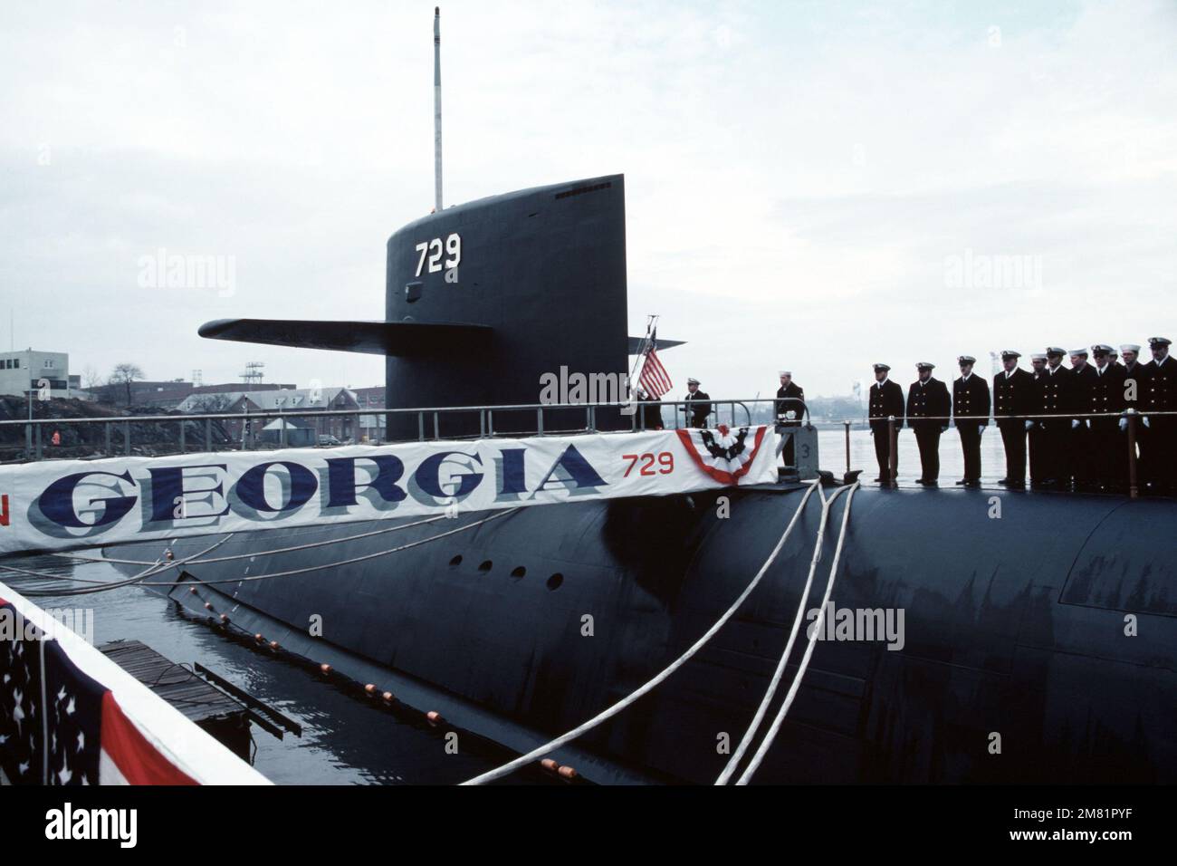 Members of the crew line the deck during the commissioning ceremony for ...