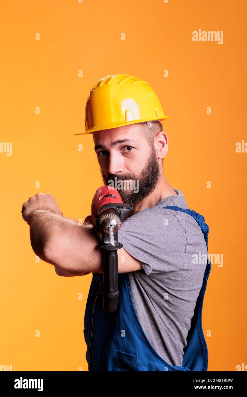 Male carpenter expert drilling holes with electric nail gun, using ...