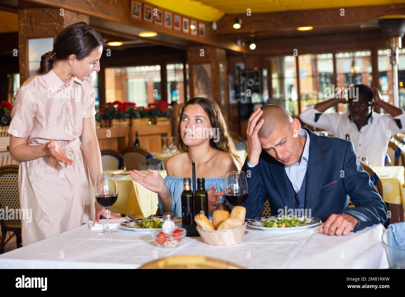 Wife scolding husband spending time with another woman in restaurant ...