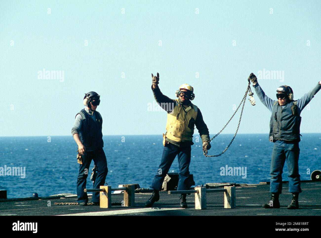 Flight deck crewmen aboard the amphibious assault ship USS GUAM (LPH 9 ...