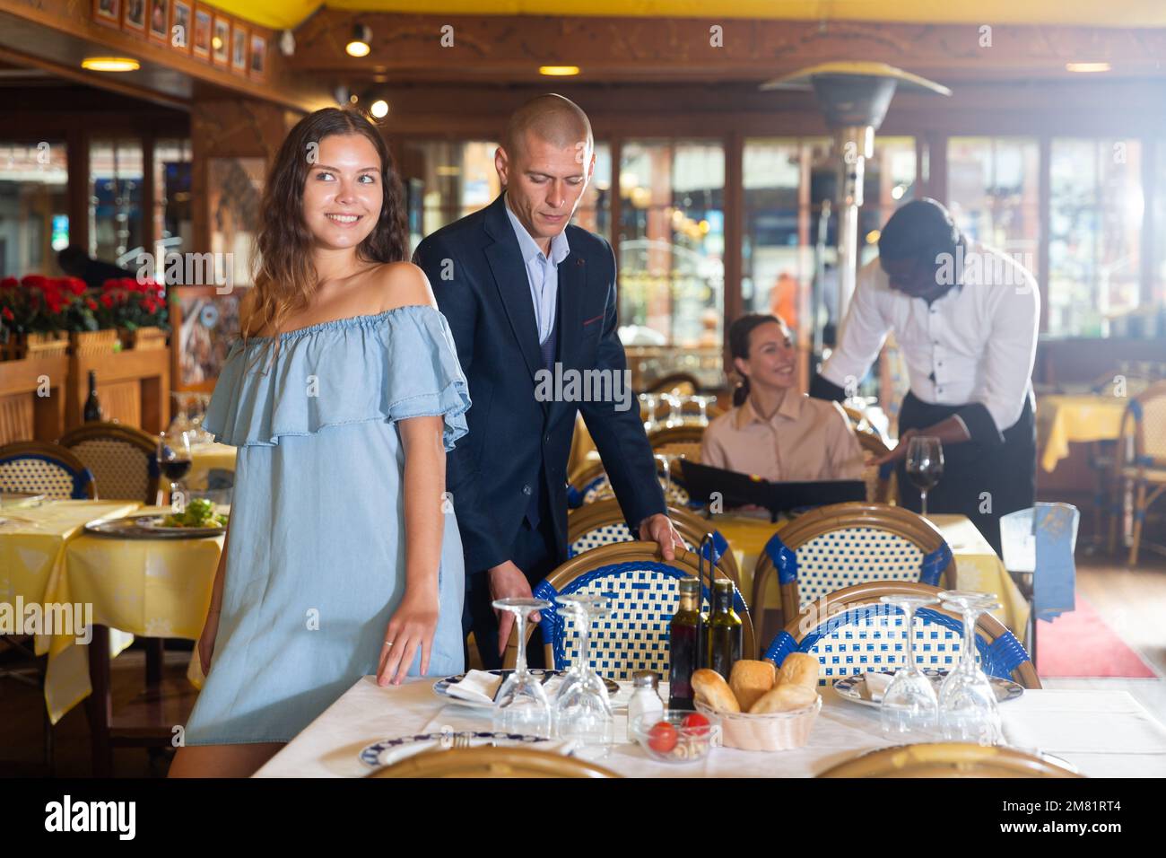 Portrait of a young elegant couple visiting restaurant Stock Photo - Alamy