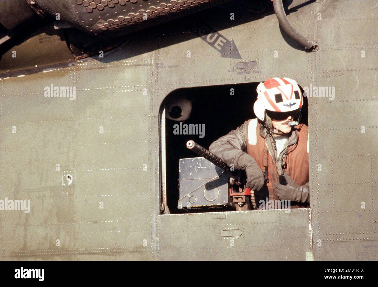 A Marine leans on a .50-caliber machine gun mounted on a CH-53E ...