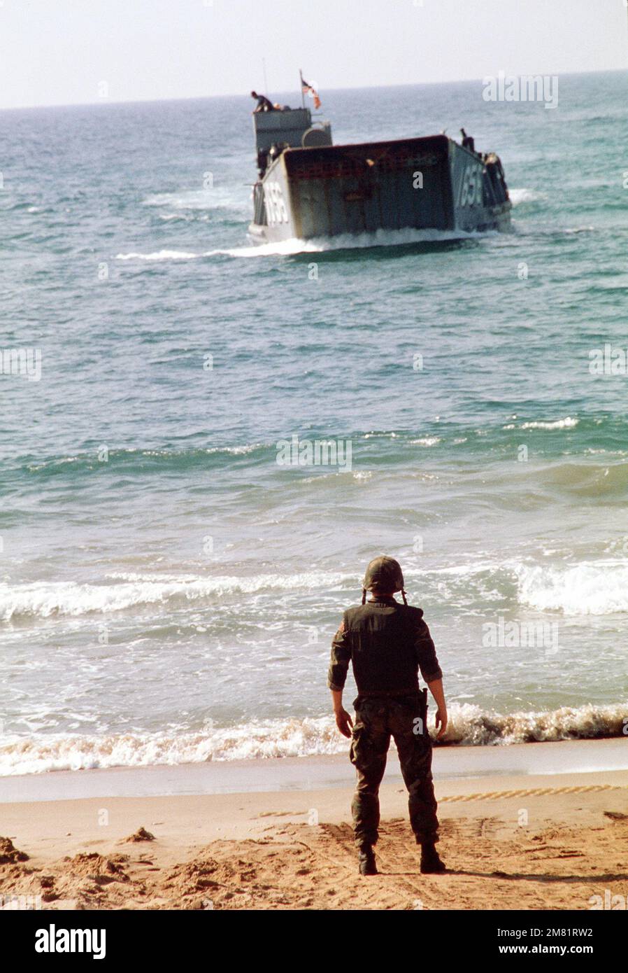 A Marine beachmaster from the 22nd Marine Amphibious Unit, watches from ...