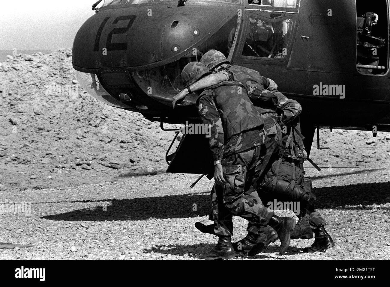 Marines carry a wounded fellow Marine toward a CH-46 Sea Knight ...