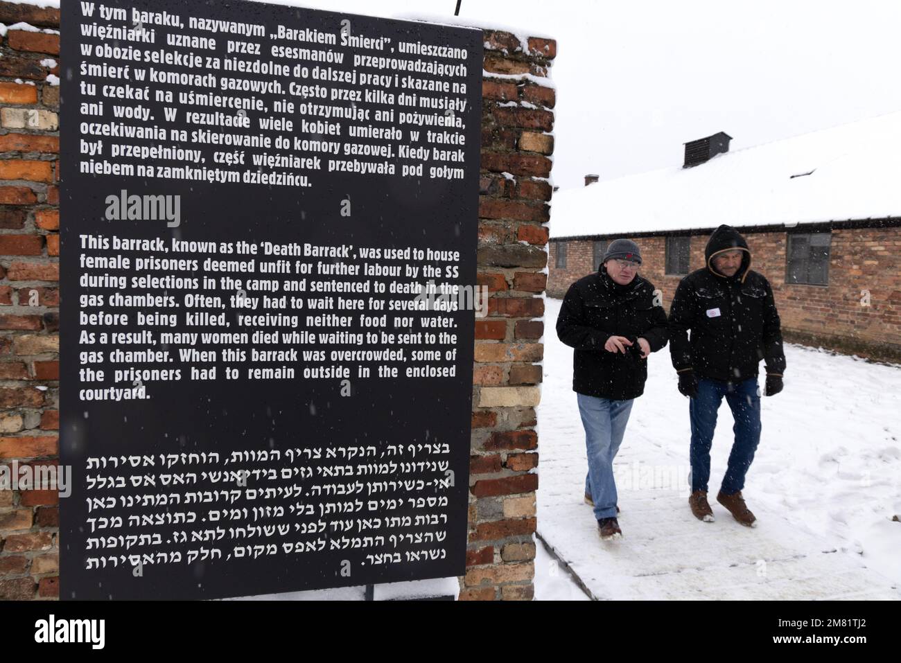 Auschwitz tourists and sign; men emerging from the Death Barrack ...