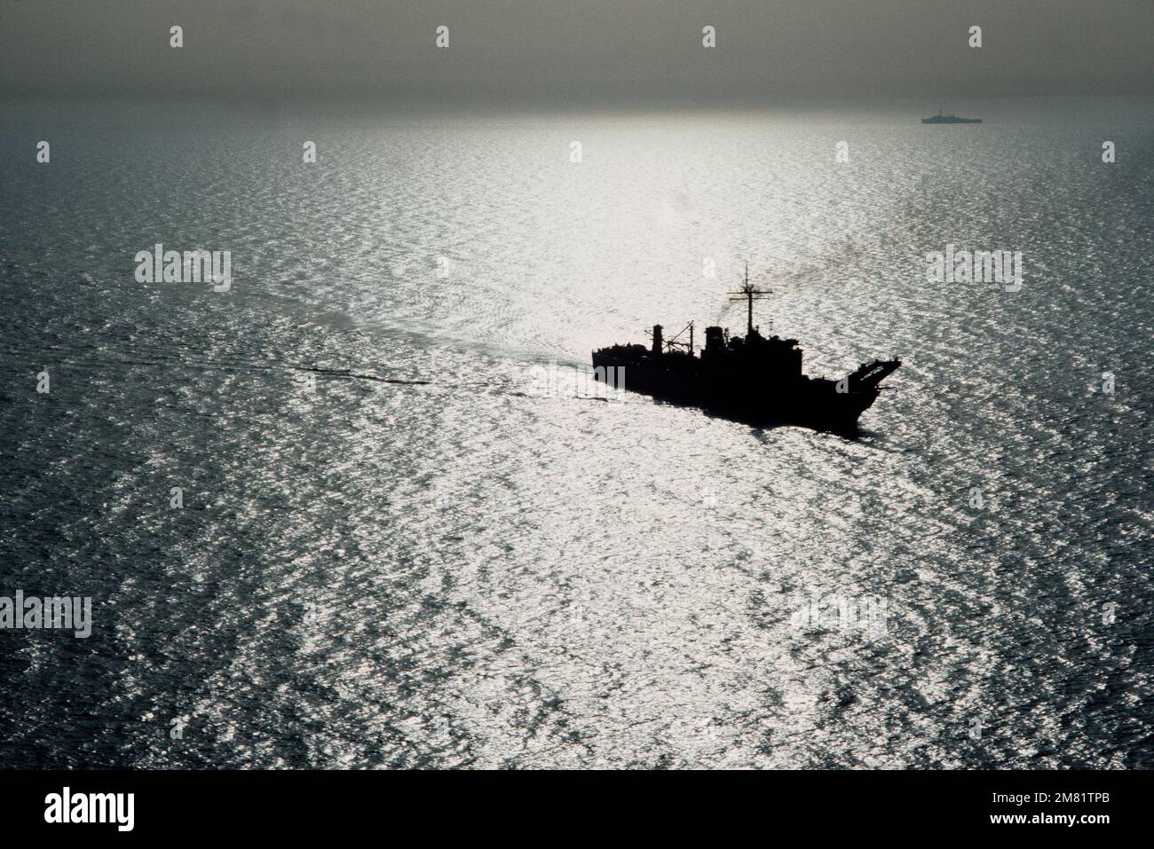 A silhouetted starboard bow view of the tank landing ship USS ...