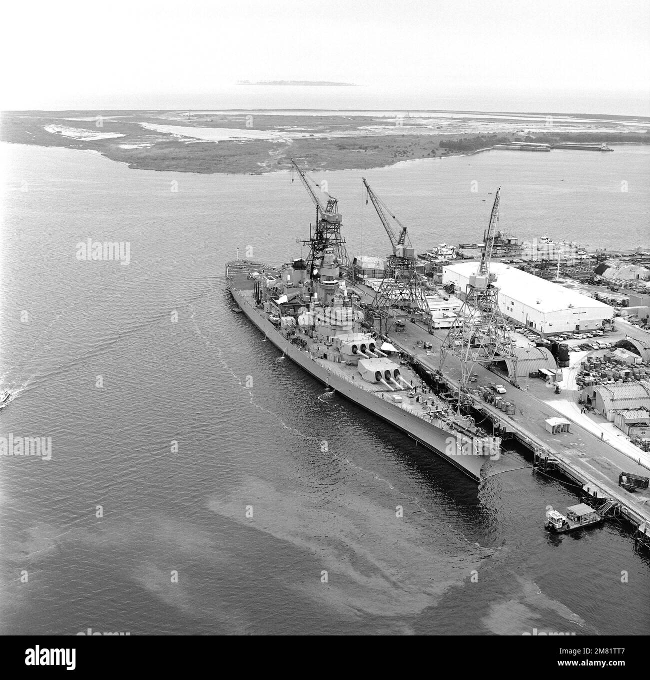 An elevated starboard bow view of the battleship USS IOWA (BB 61) undergoing modernization ...