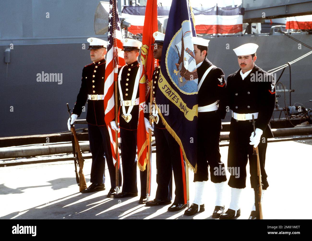 A Navy-Marine Corps color guard stands at attention during the ...