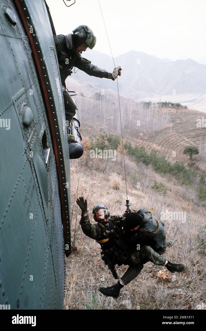 A pararescueman and a "downed" pilot are hoisted aboard an HH-3C ...