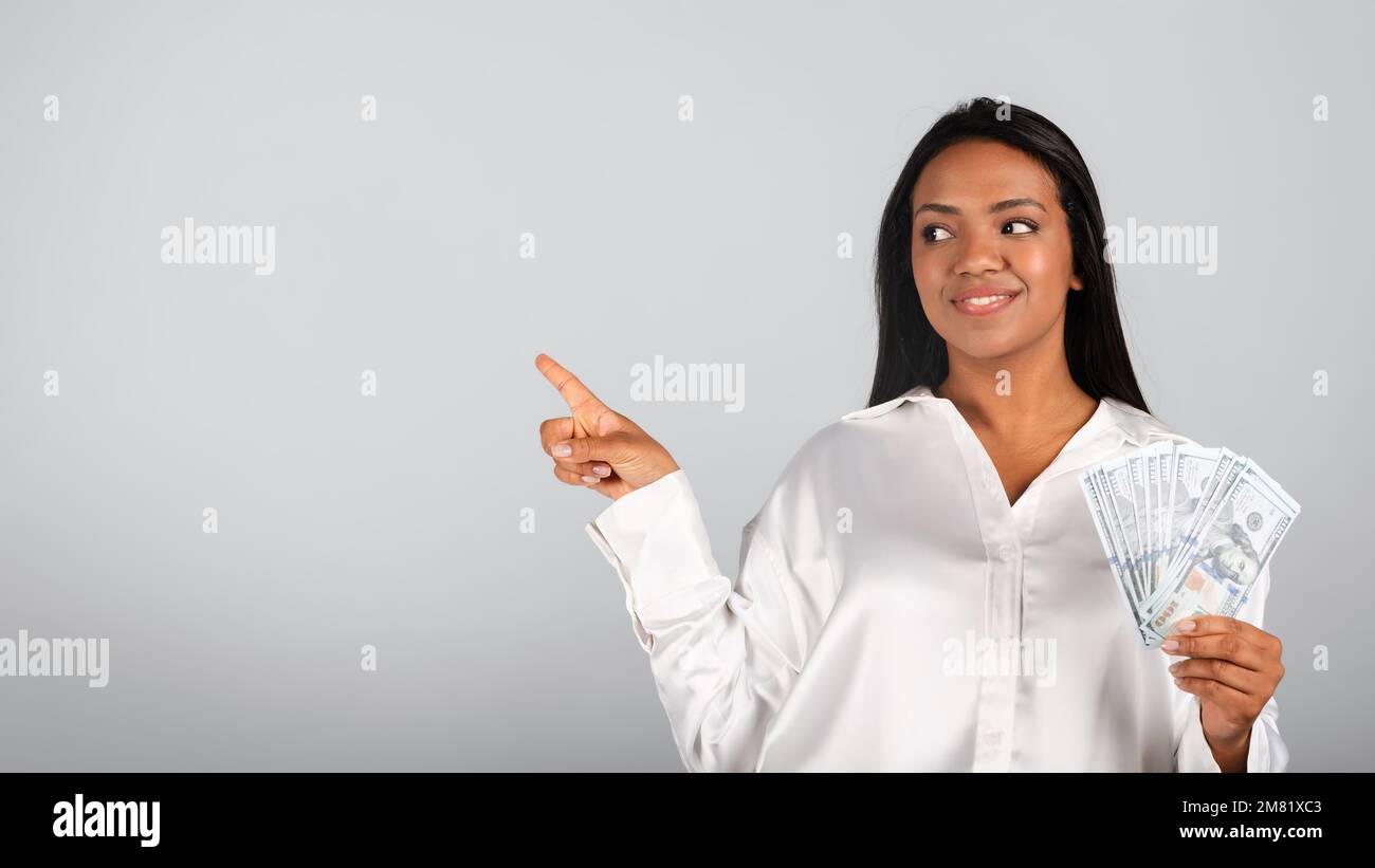 Smiling confident millennial black businesswoman hold lot of money ...