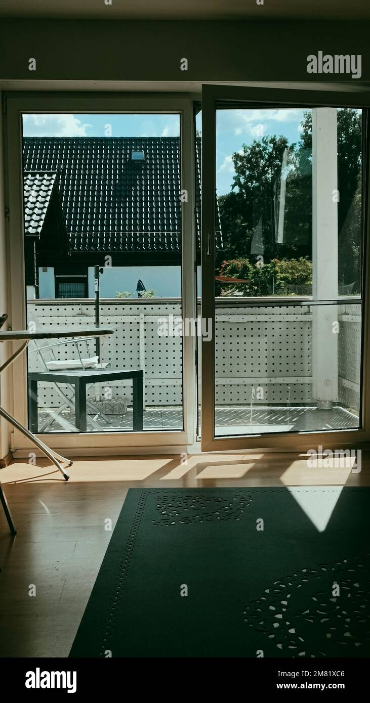 A vertical of big window doors from a room with a view of house outside ...