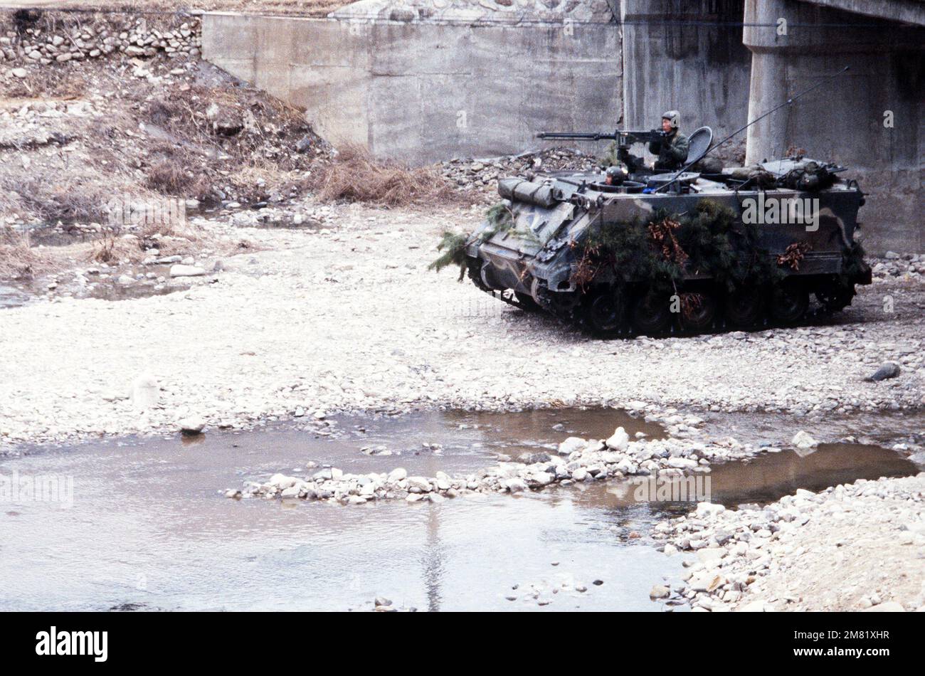 An M113 armored personnel carrier, equipped with a .50-caliber machine ...