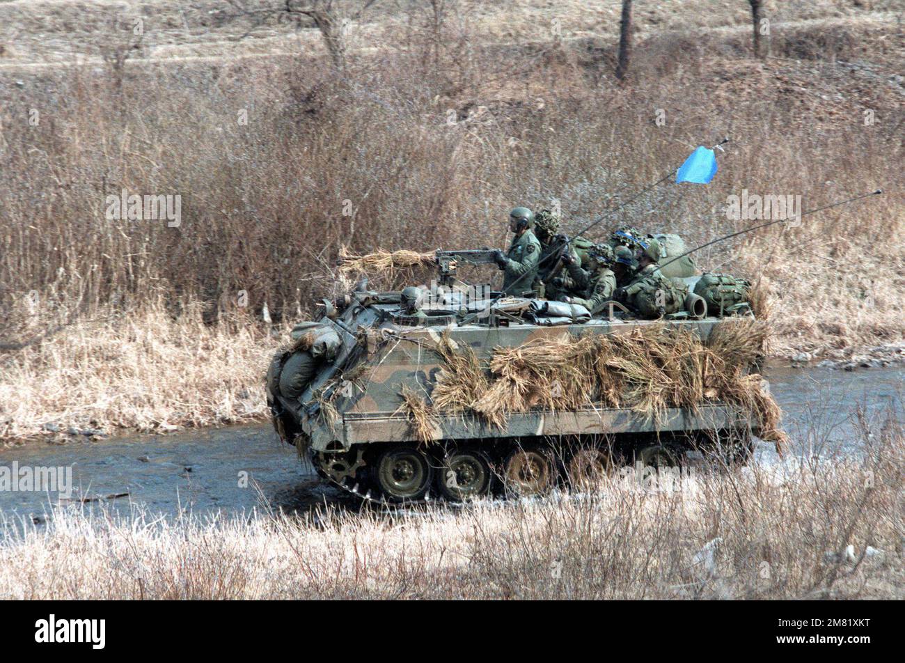 US Army personnel ride aboard a camouflaged M-113 armored personnel ...
