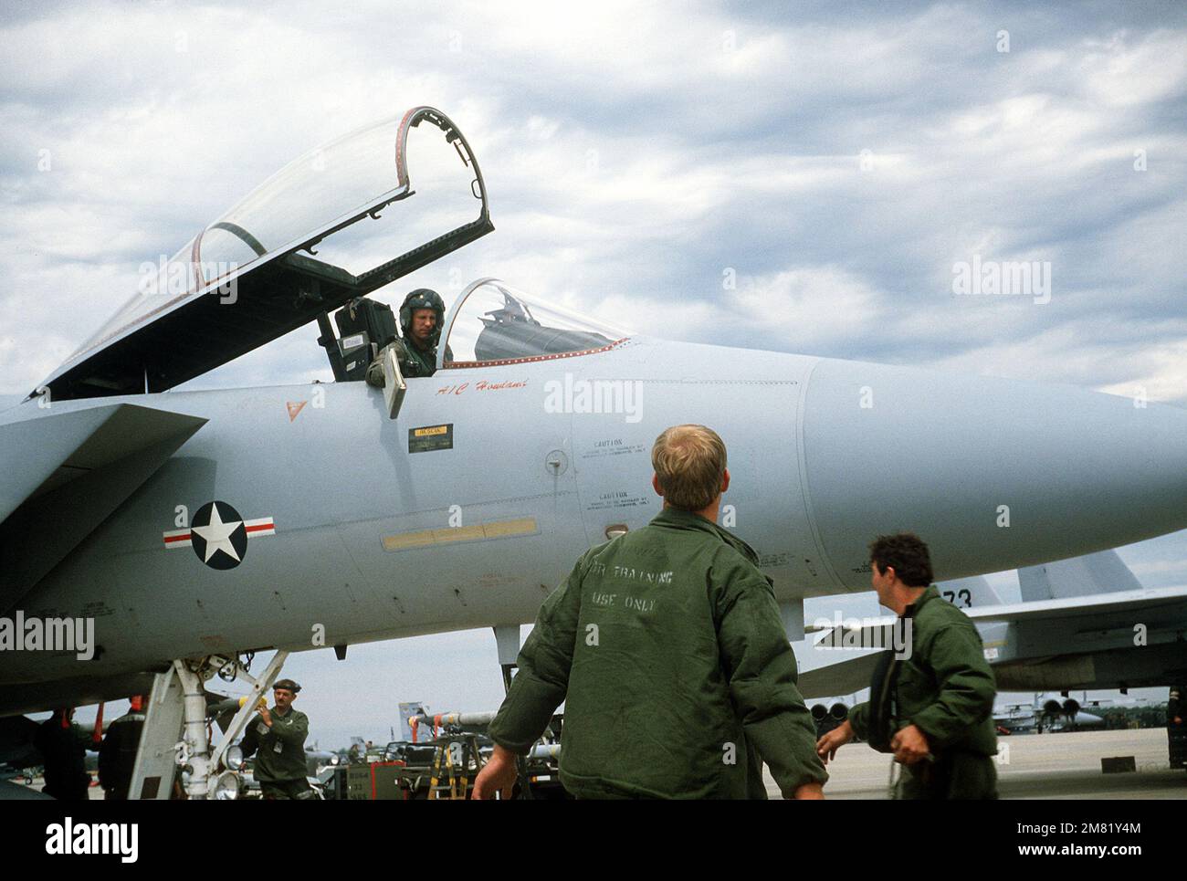 The pilot of an F-15 Eagle fighter aircraft opens the canopy of the ...