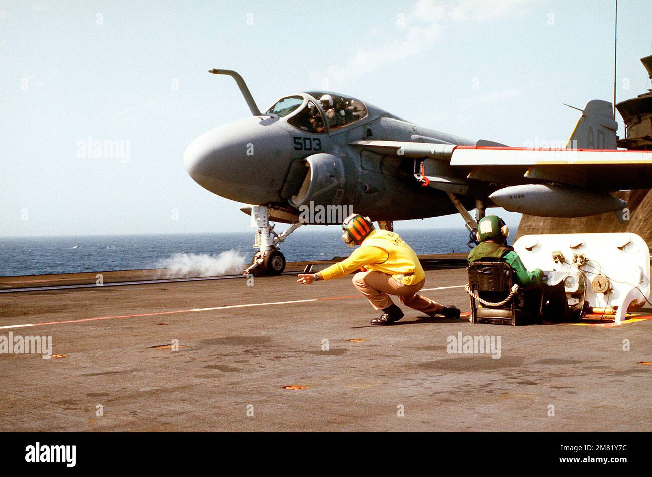 A catapult officer signals to launch an A-6 Intruder aircraft from the ...