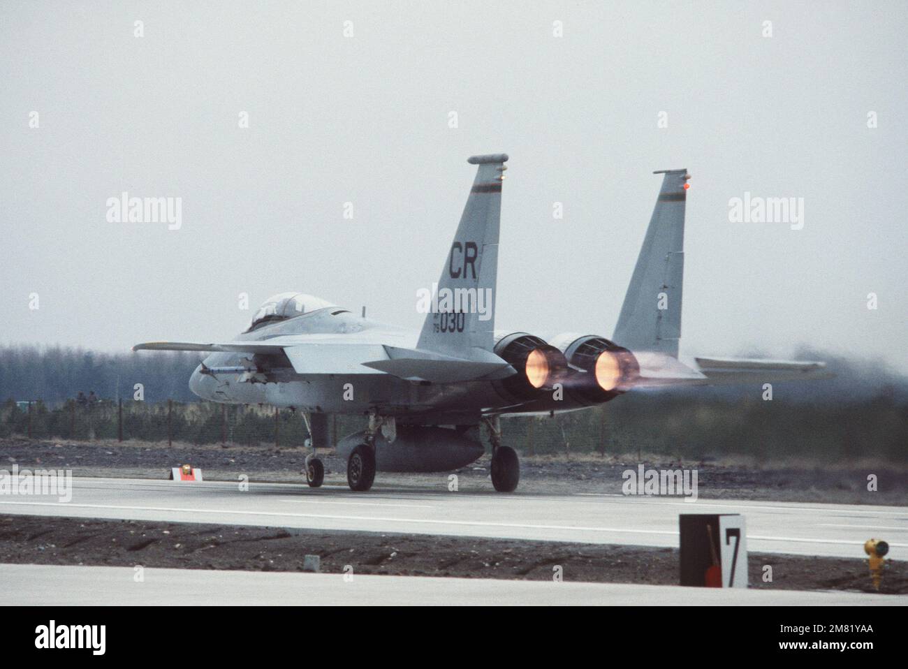 A left rear view of an F-15 Eagle aircraft taking off during an air ...